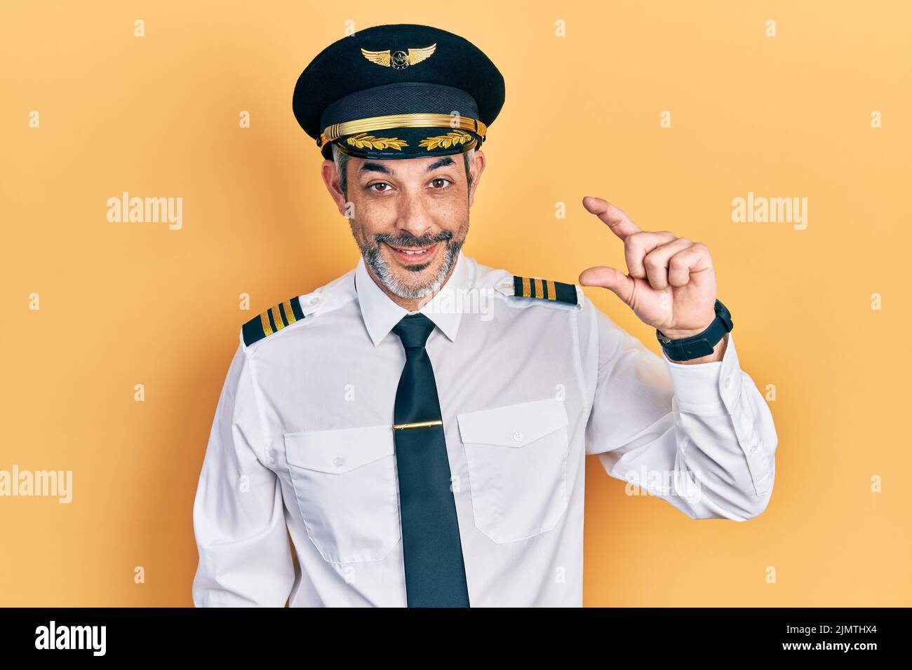 Handsome middle age man with grey hair wearing airplane pilot uniform ...