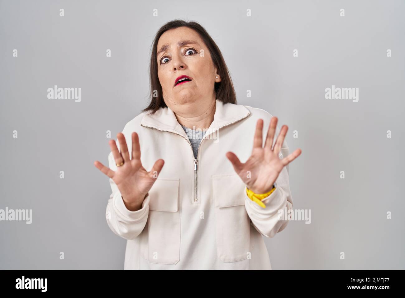 Middle age hispanic woman standing over isolated background moving away ...