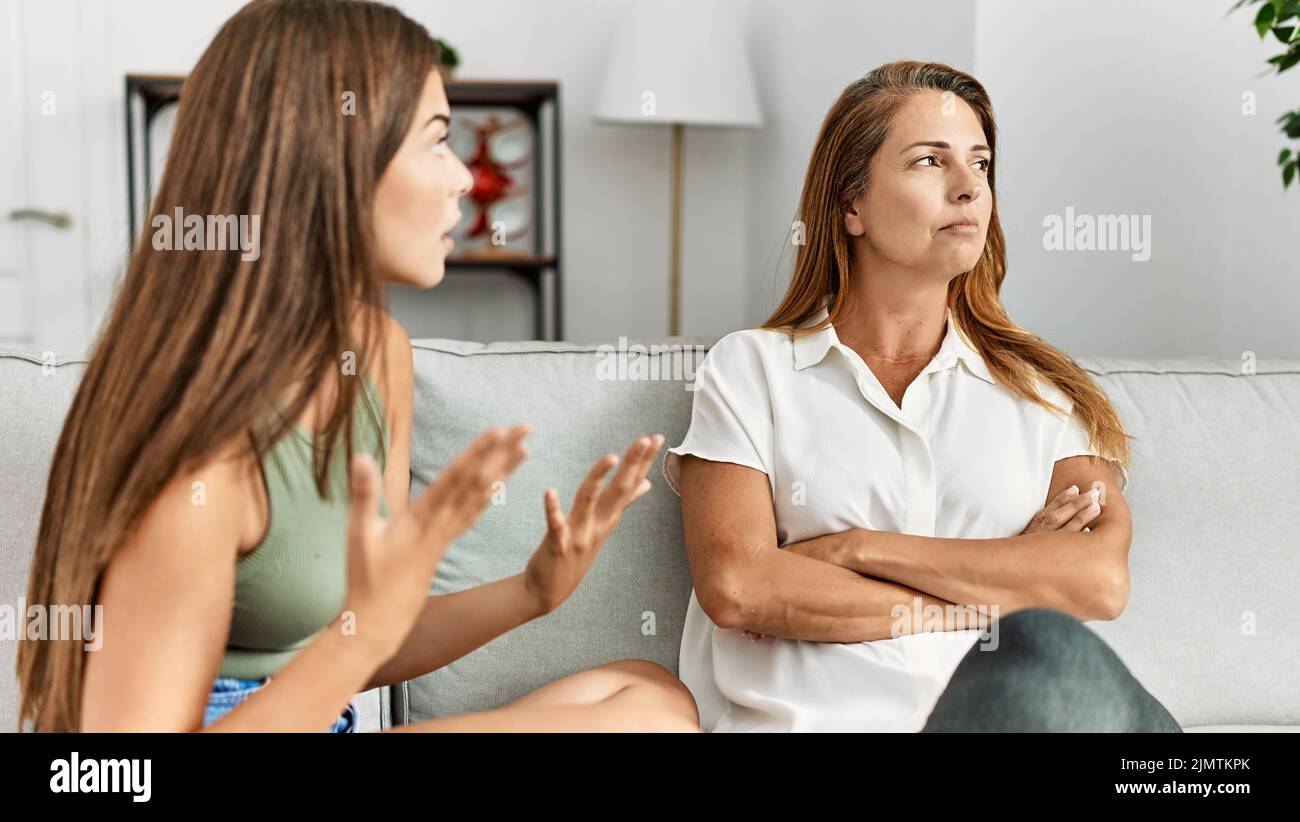 Mother and daughter unhappy arguing sitting on sofa at home Stock Photo ...
