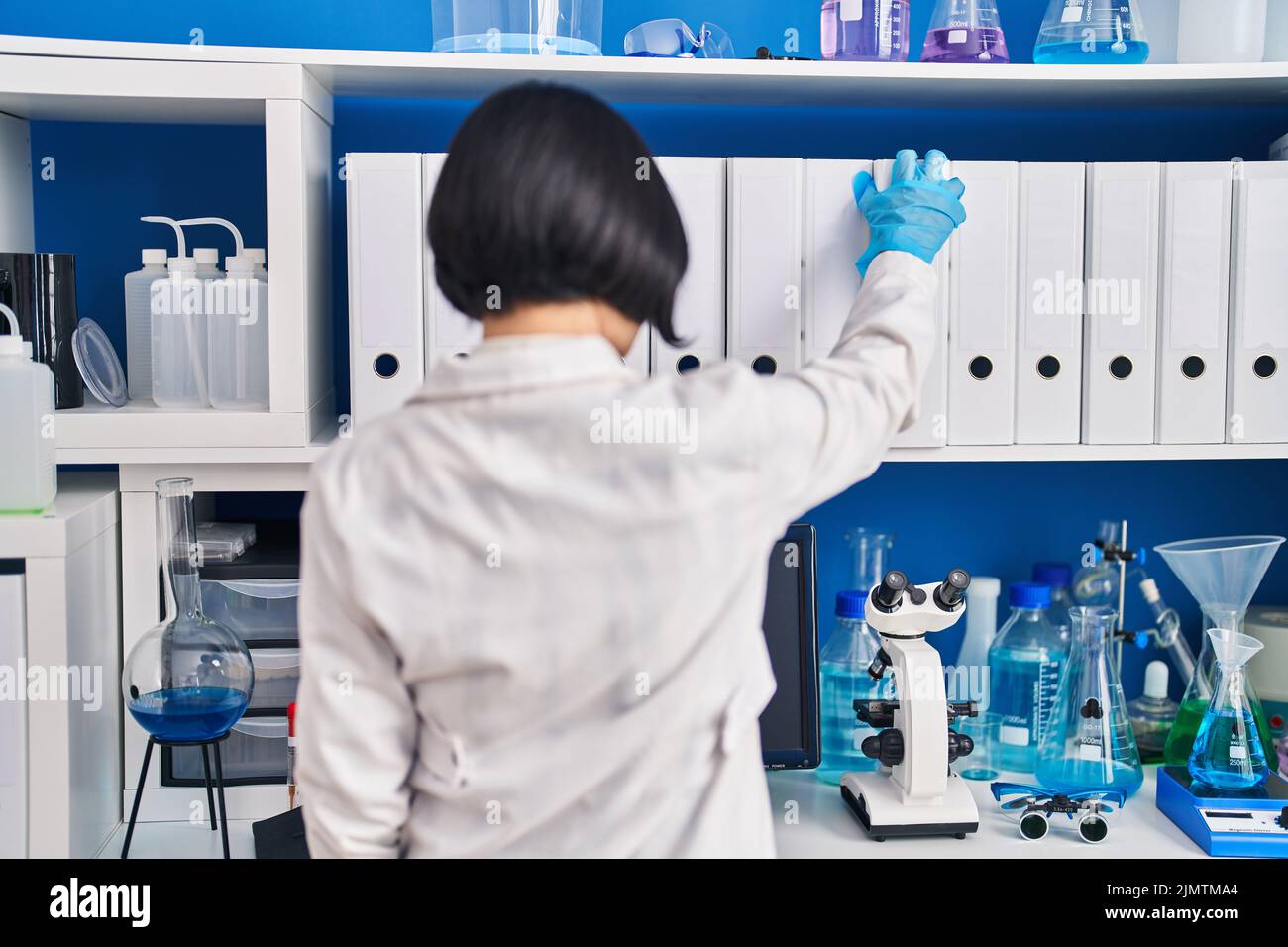 Young chinese woman scientist holding binder at laboratory Stock Photo ...