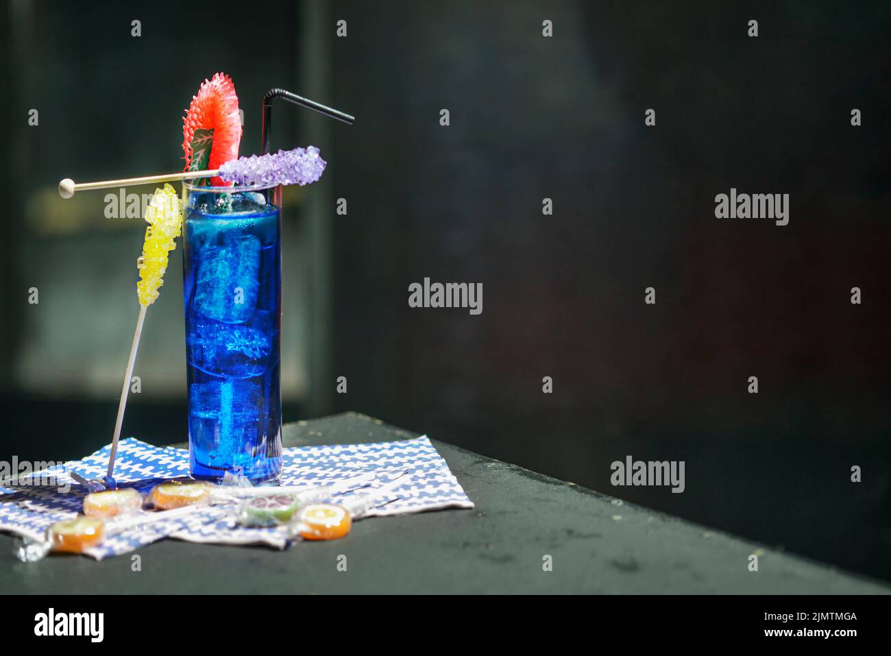 Take a cold drink with lots of ice, assorted sweets and blue liquid in ...