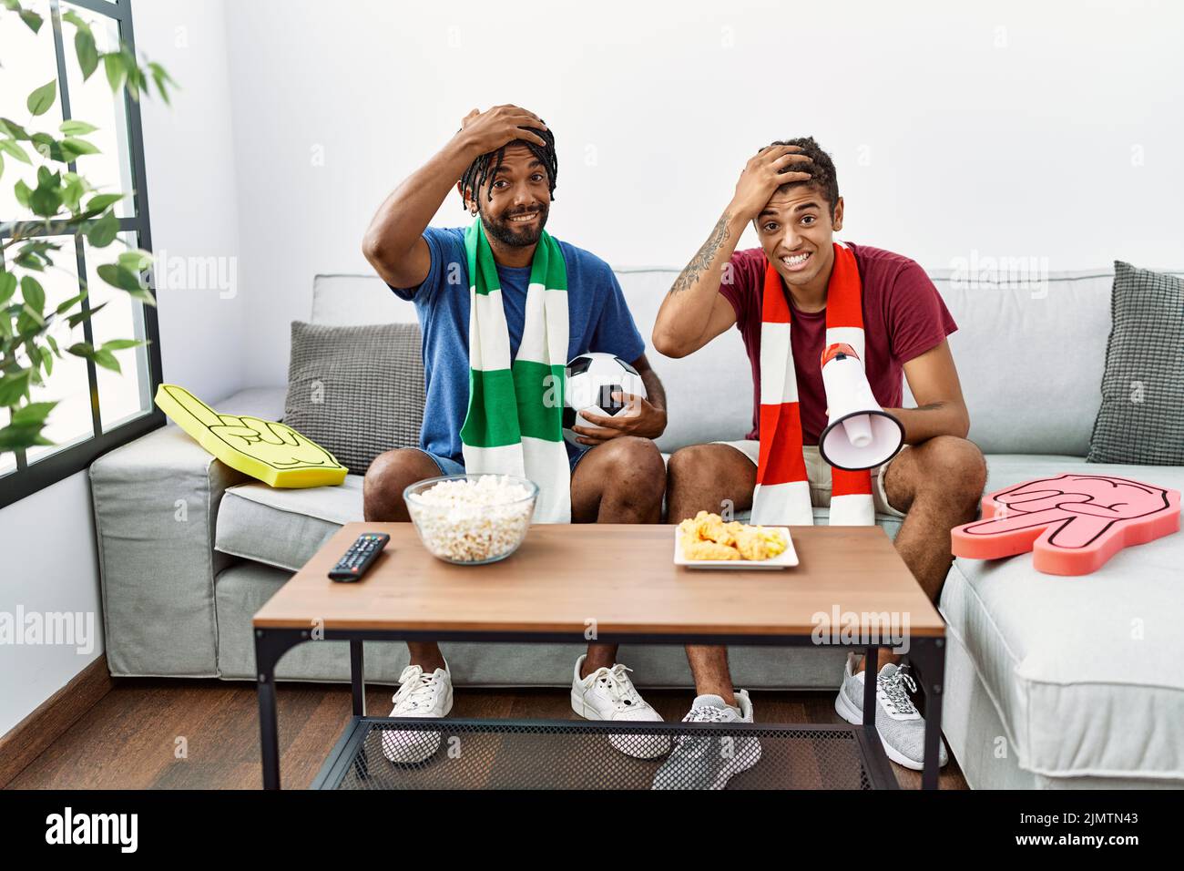 Young hispanic brothers football hooligans holding ball and megaphone ...