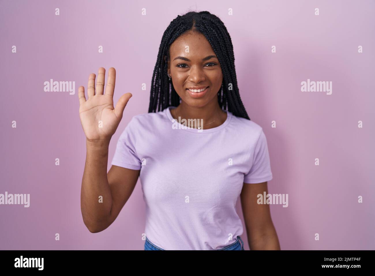 African american woman with braids standing over pink background ...