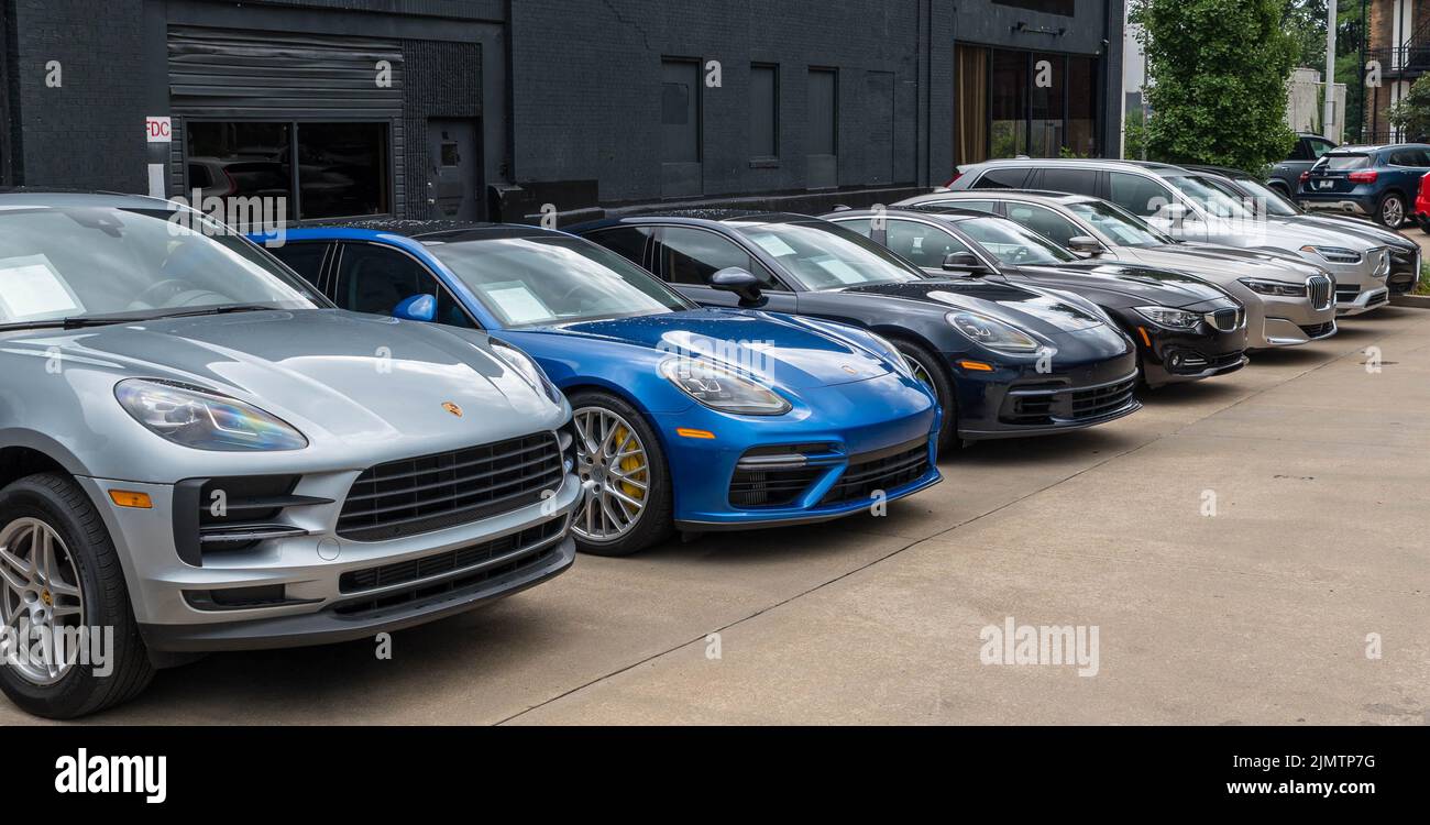 Various used luxury vehicles for sale lined up at a dealership in ...