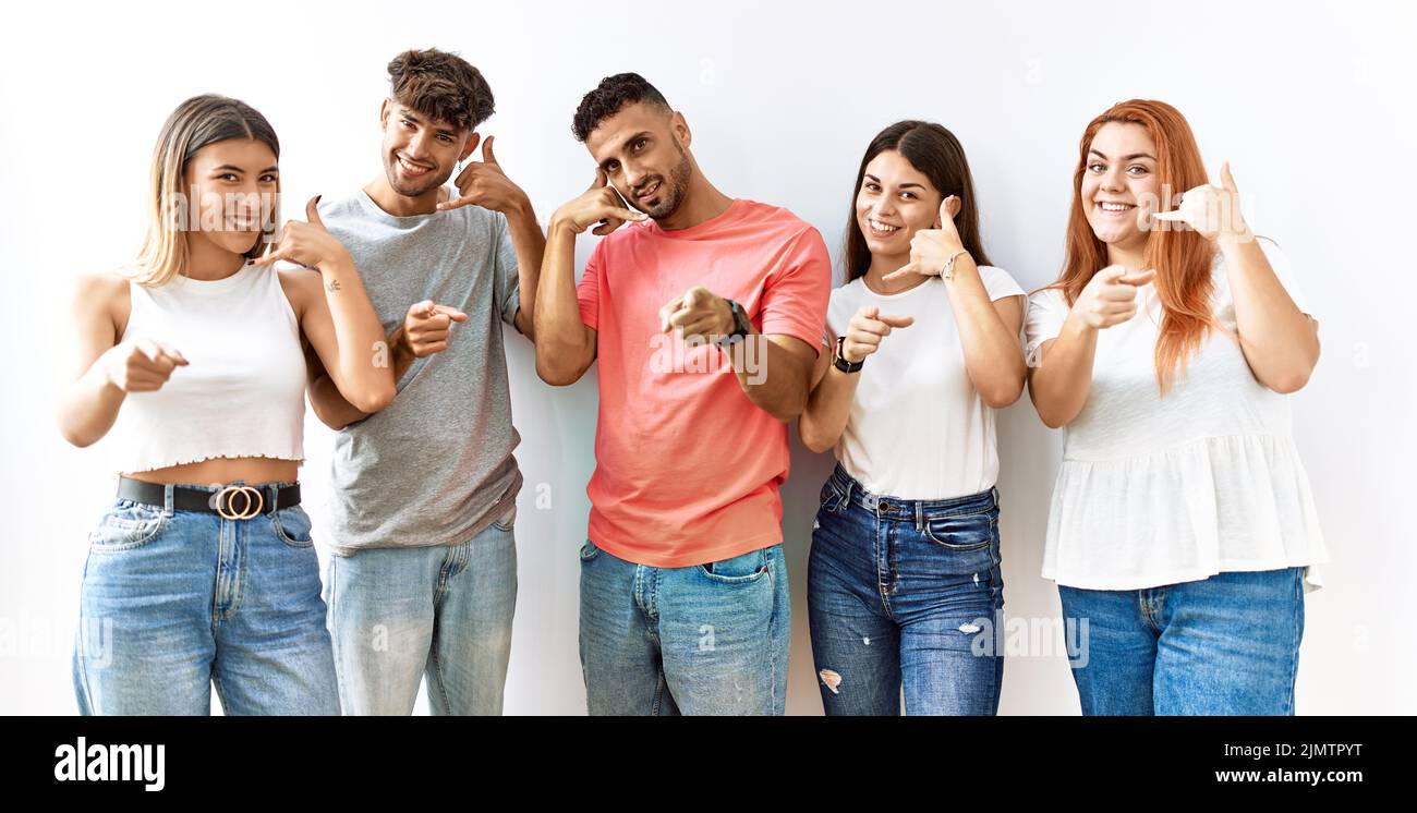 Group of young friends standing together over isolated background ...