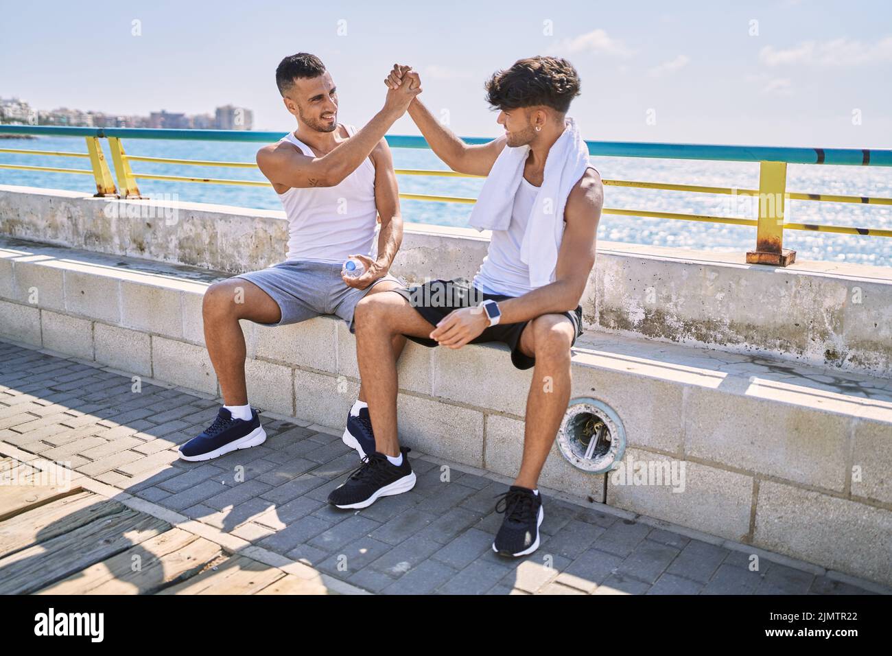 Two hispanic men couple smiling confident high five with hands raised ...
