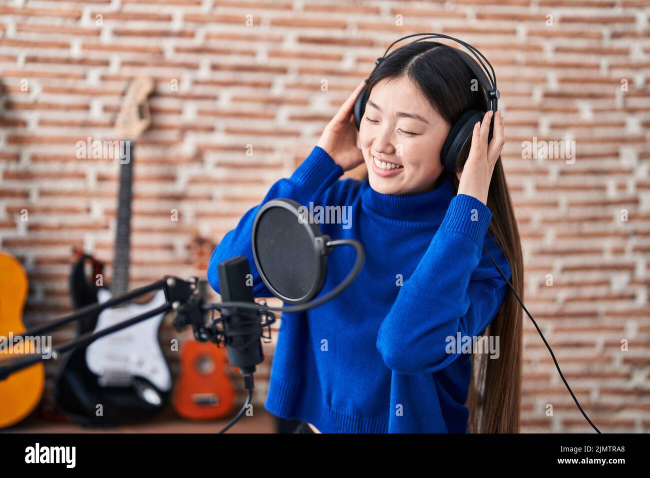 Chinese woman artist singing song at music studio Stock Photo - Alamy
