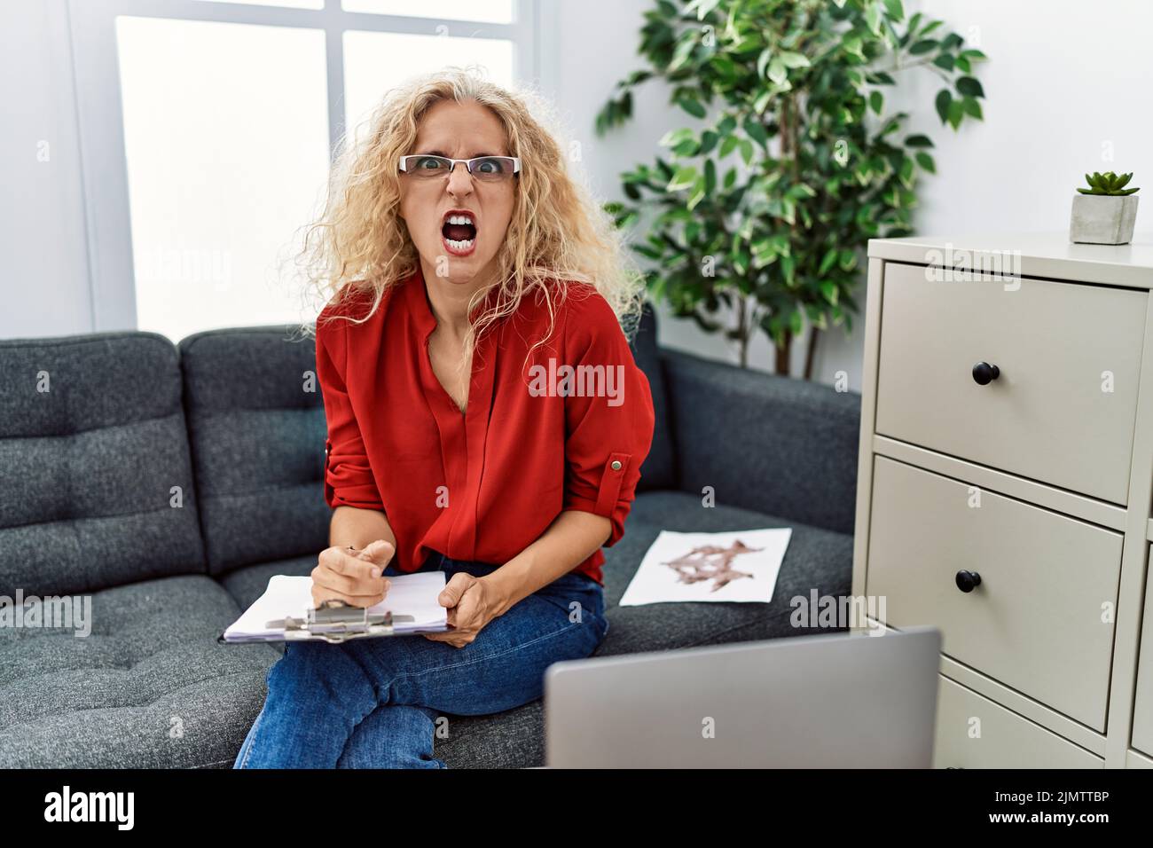 Middle age psychologist woman at consultation office angry and mad ...
