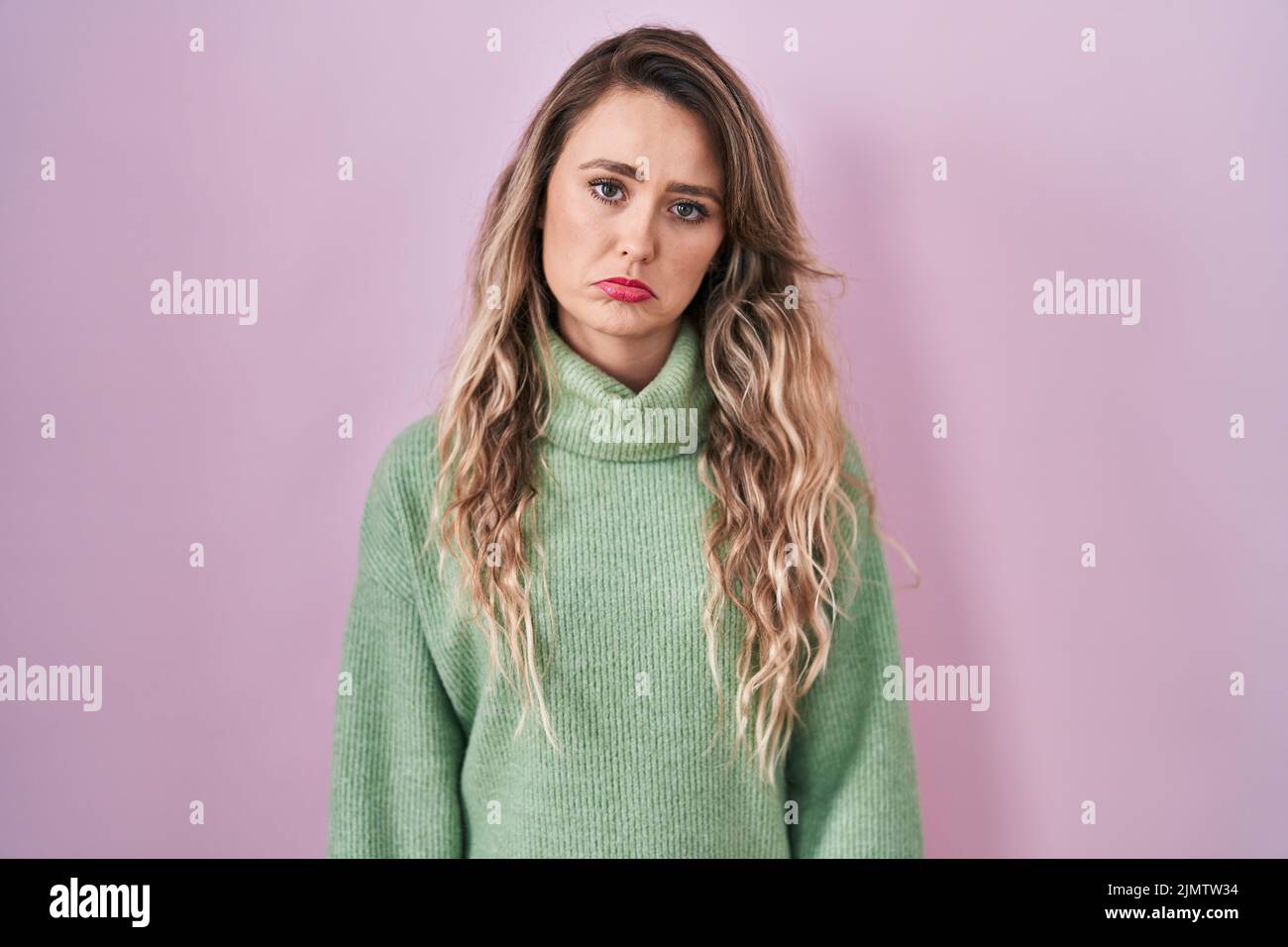 Young caucasian woman standing over pink background depressed and worry ...