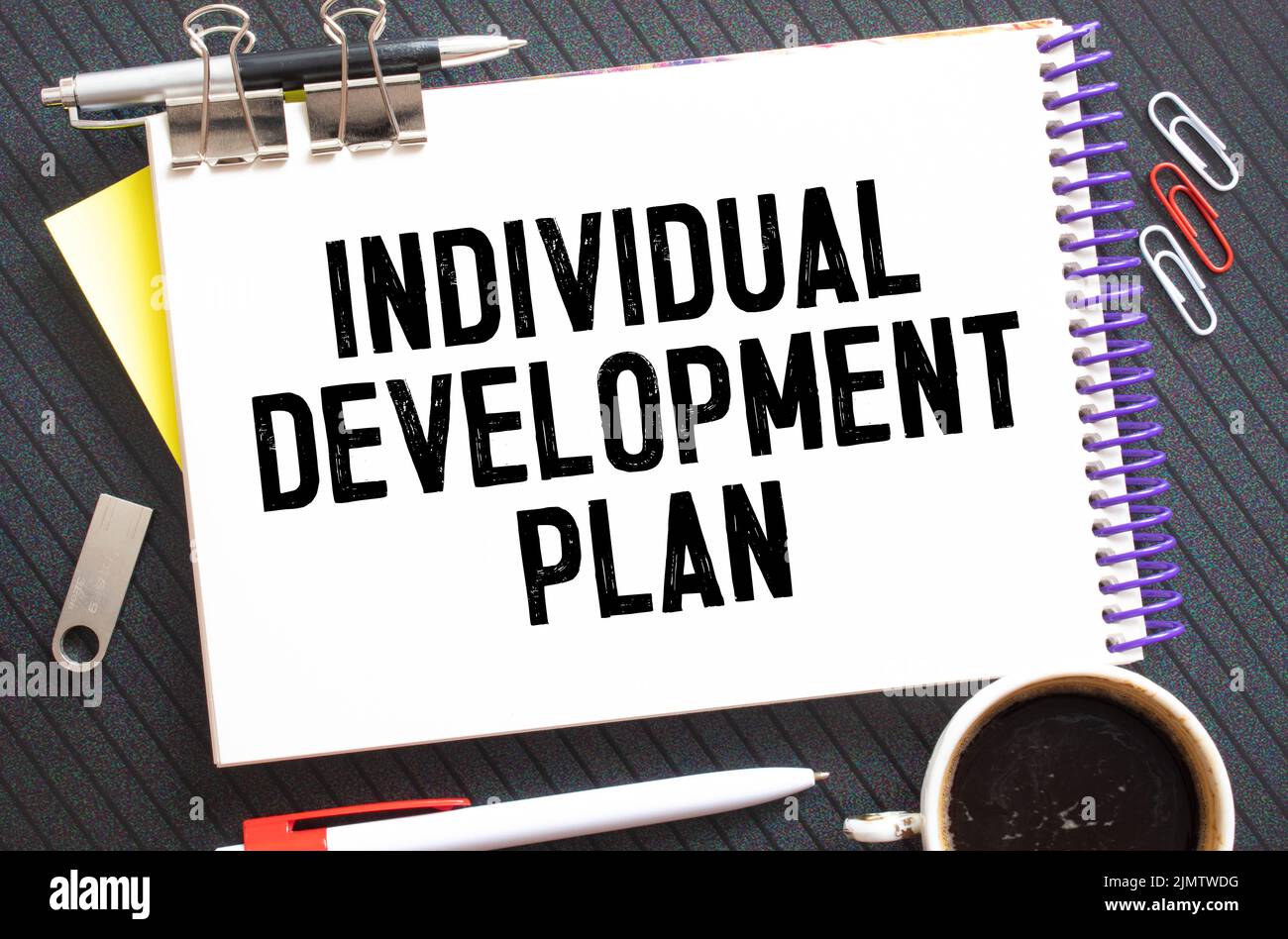 Closeup on businessman holding a card with text INDIVIDUAL DEVELOPMENT ...