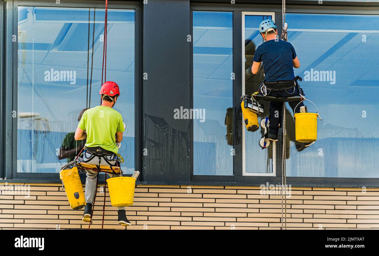 Two men cleaning windows on an office building Stock Photo - Alamy