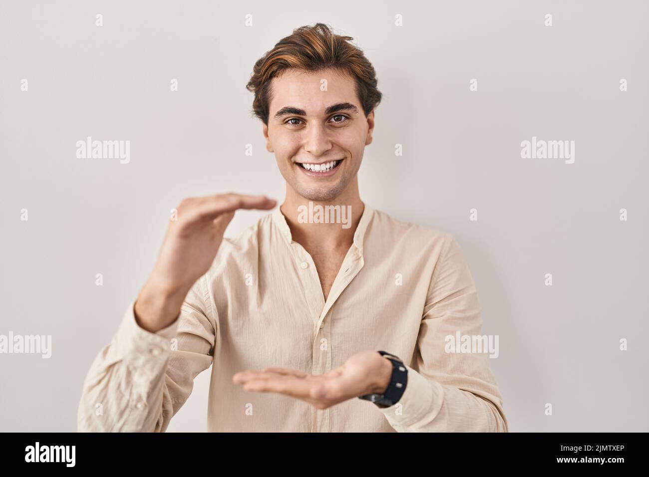 Young man standing over isolated background gesturing with hands ...