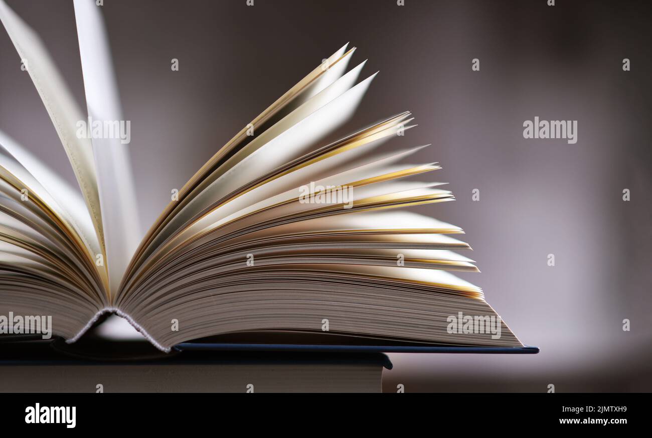 A composition with an open book lying on a stack of other books Stock ...