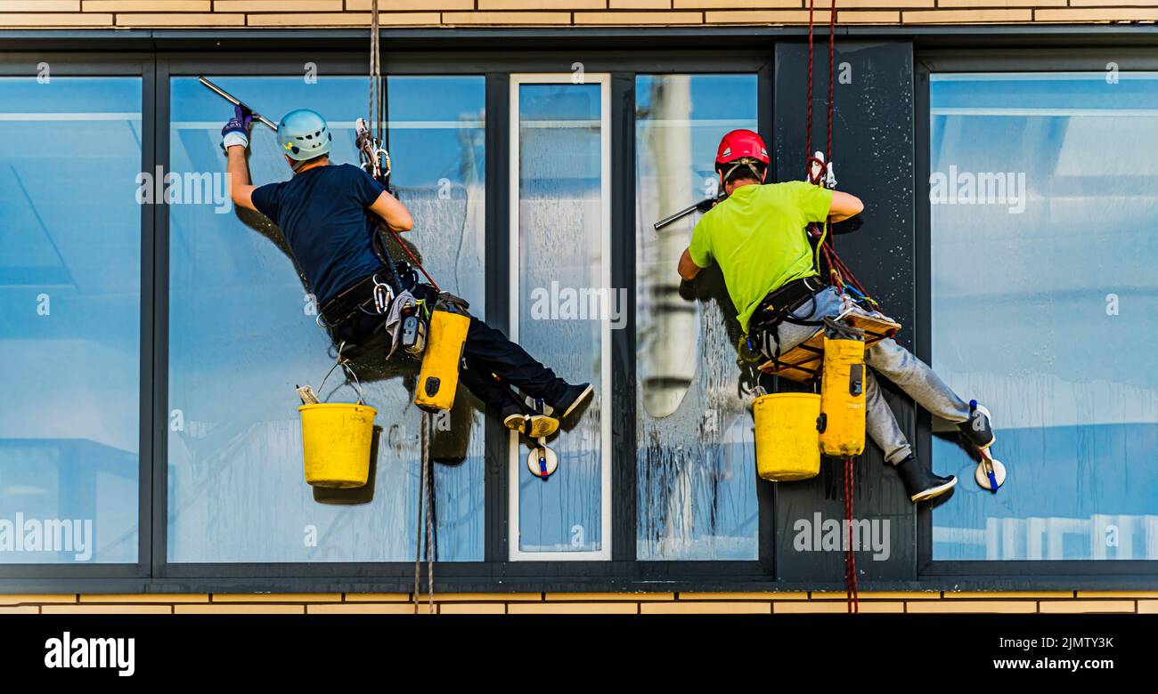 Two men cleaning windows on an office building Stock Photo - Alamy