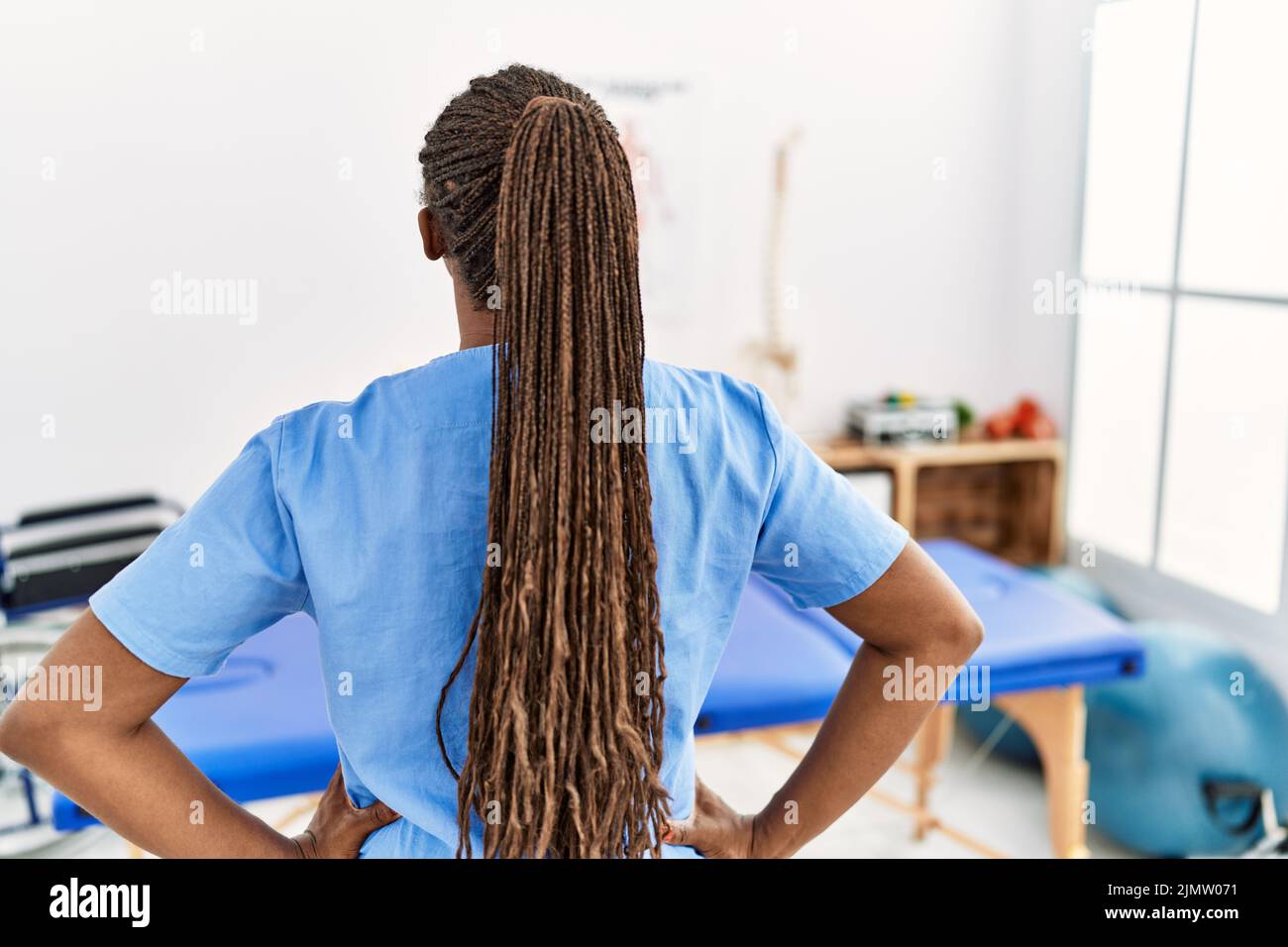Black woman with braids working at pain recovery clinic standing ...