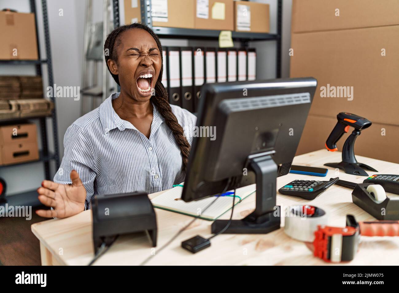 African woman working at small business ecommerce angry and mad ...
