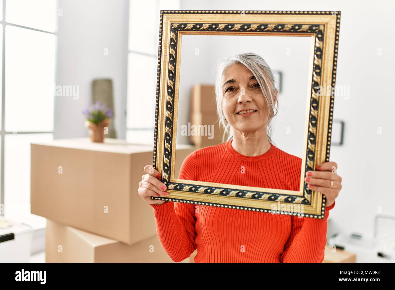 Middle age grey-haired woman smiling confident holding empty frame at ...