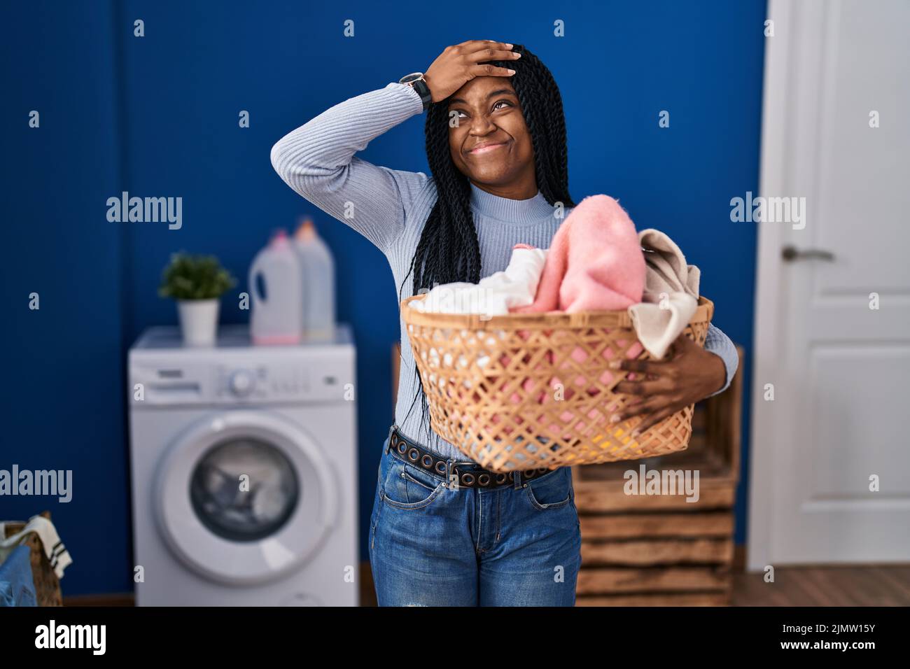 African american woman holding laundry basket stressed and frustrated ...