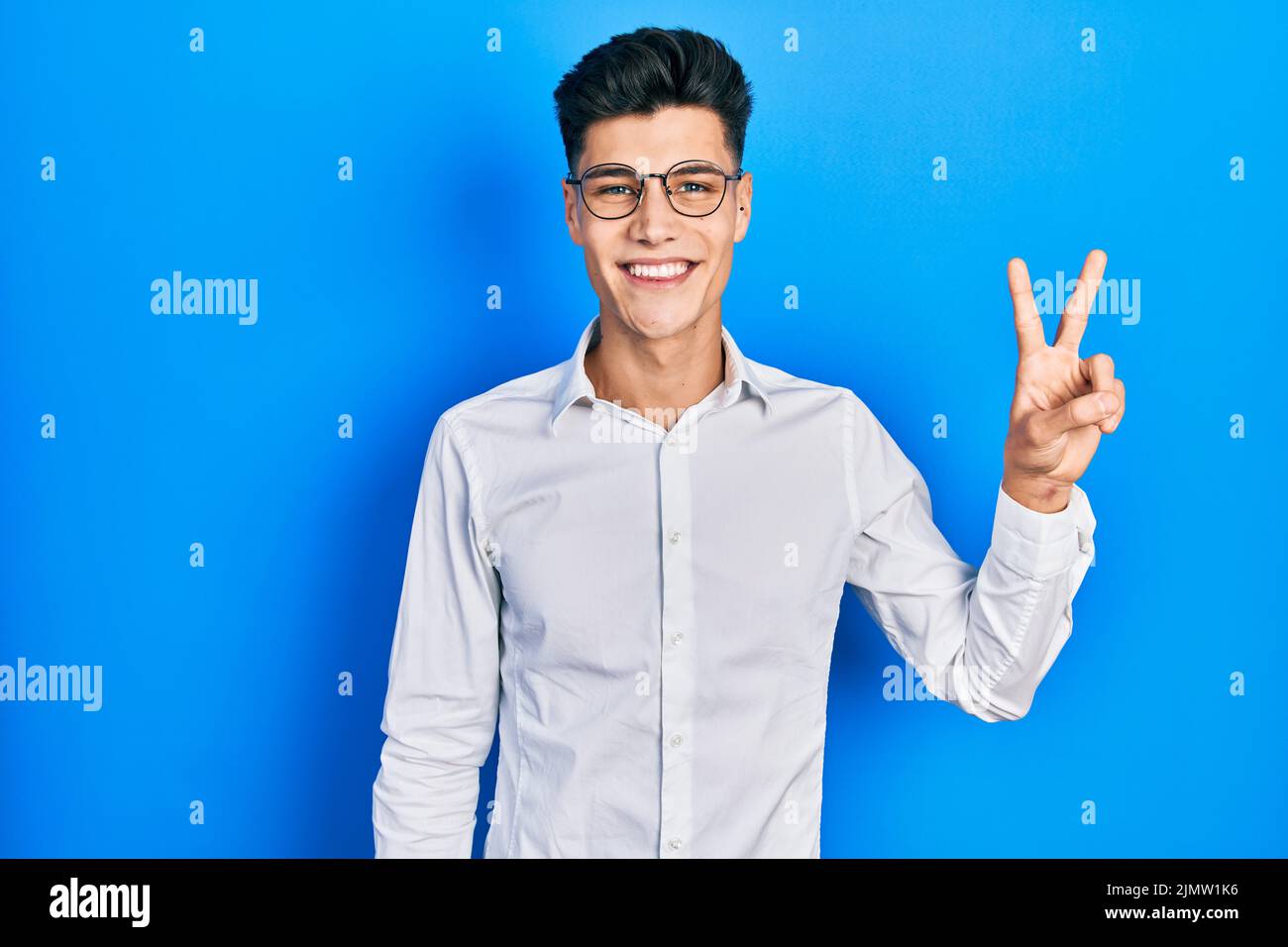 Young hispanic man wearing casual clothes and glasses smiling with ...