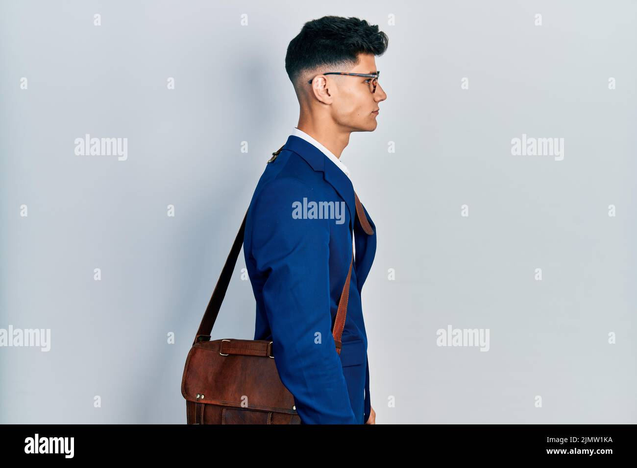 Young hispanic man wearing business clothes looking to side, relax ...