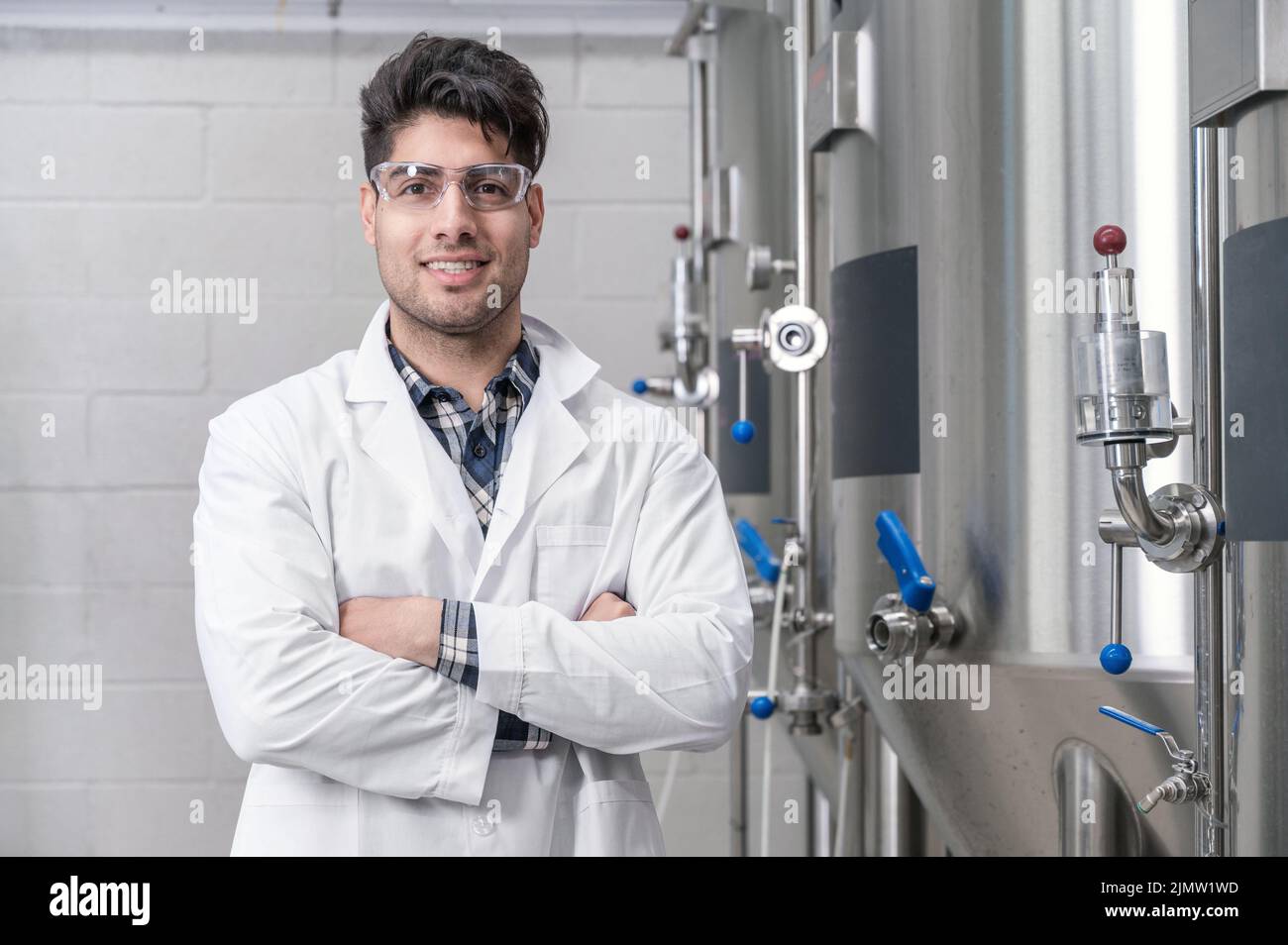 Young Handsome male worker in white lab coat smiling and looking to ...