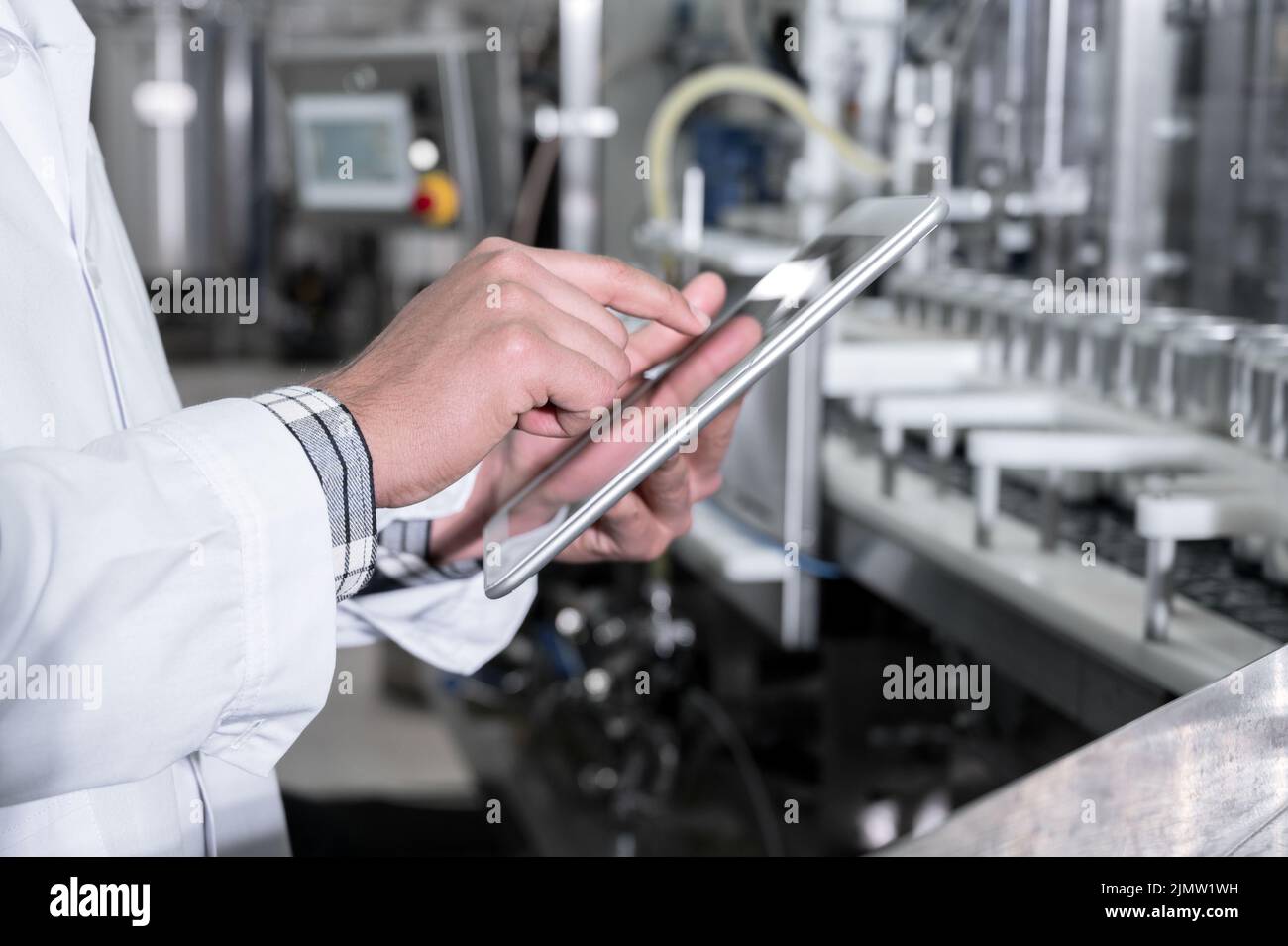 Factory worker inspecting production line on beverage factory with ...