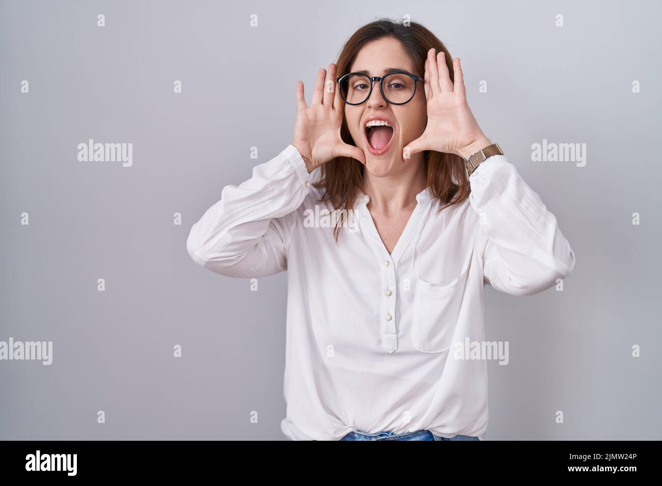 Brunette woman standing over white isolated background smiling cheerful ...