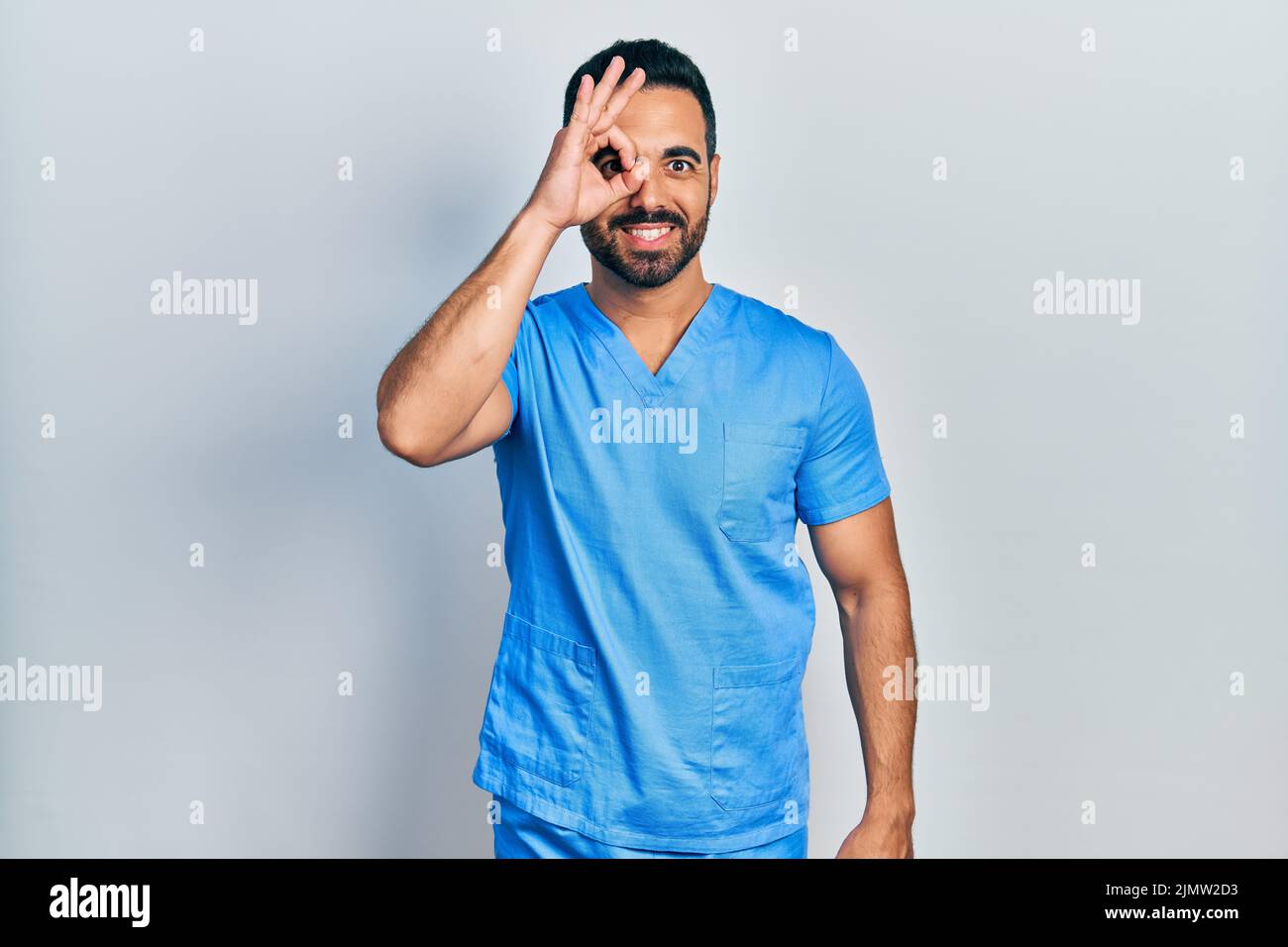 Handsome hispanic man with beard wearing blue male nurse uniform doing ...