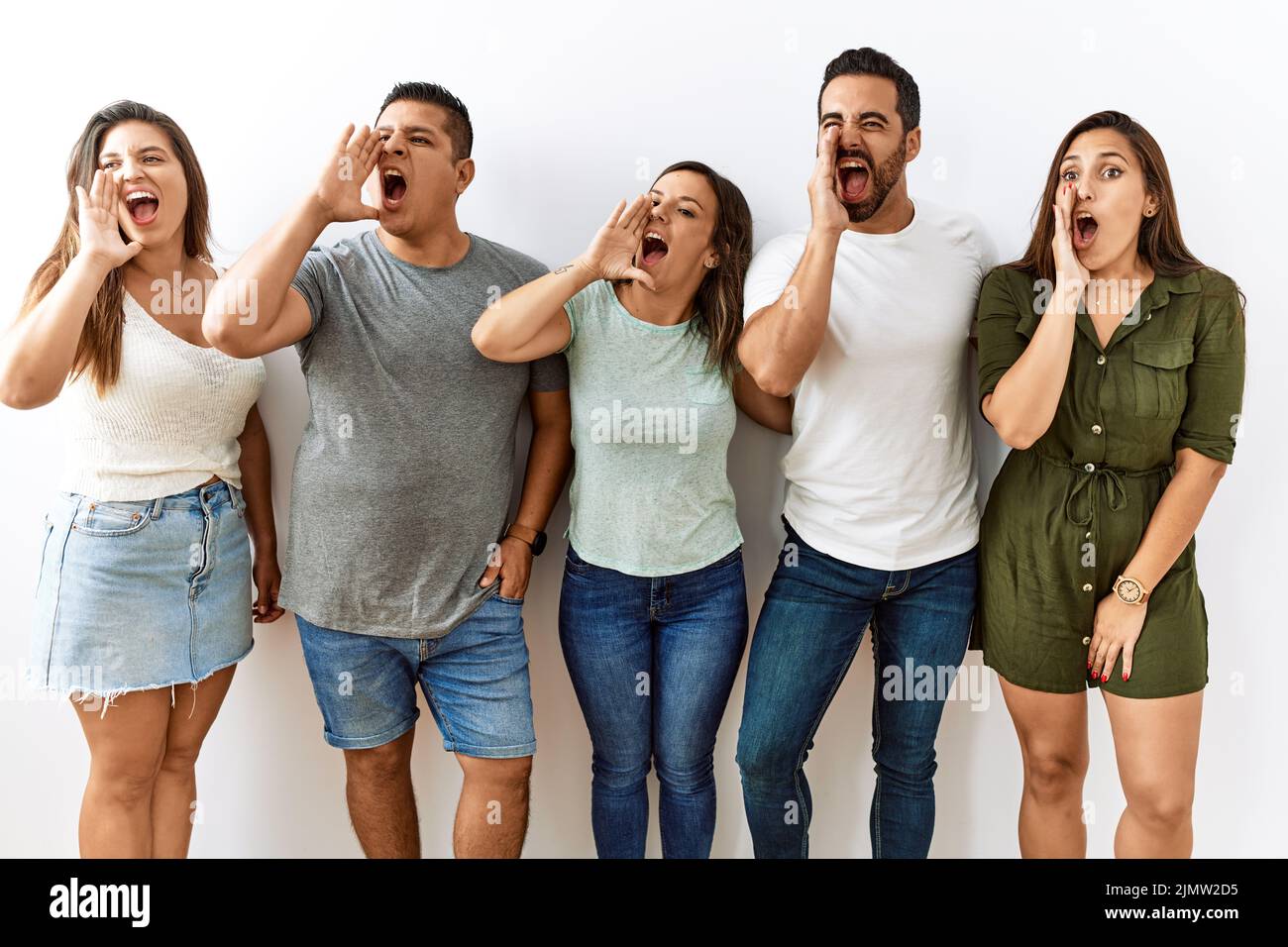 Group of young hispanic friends standing together over isolated ...