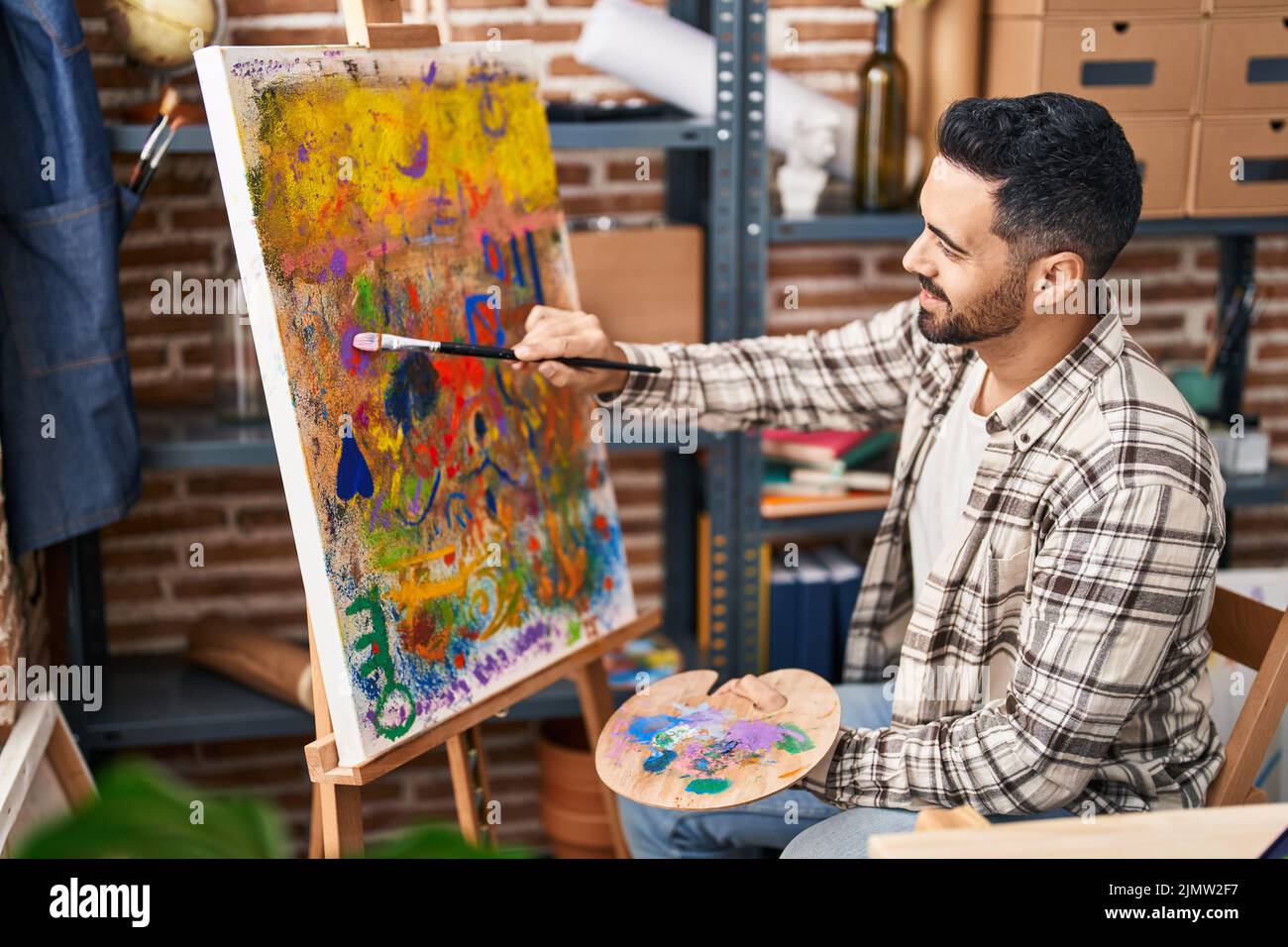 Young hispanic man smiling confident drawing at art studio Stock Photo ...