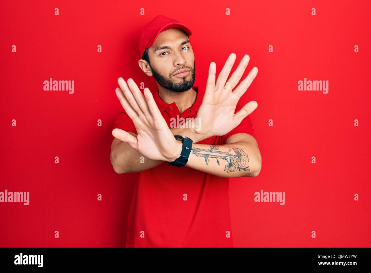 Hispanic man with beard wearing delivery uniform and cap rejection ...