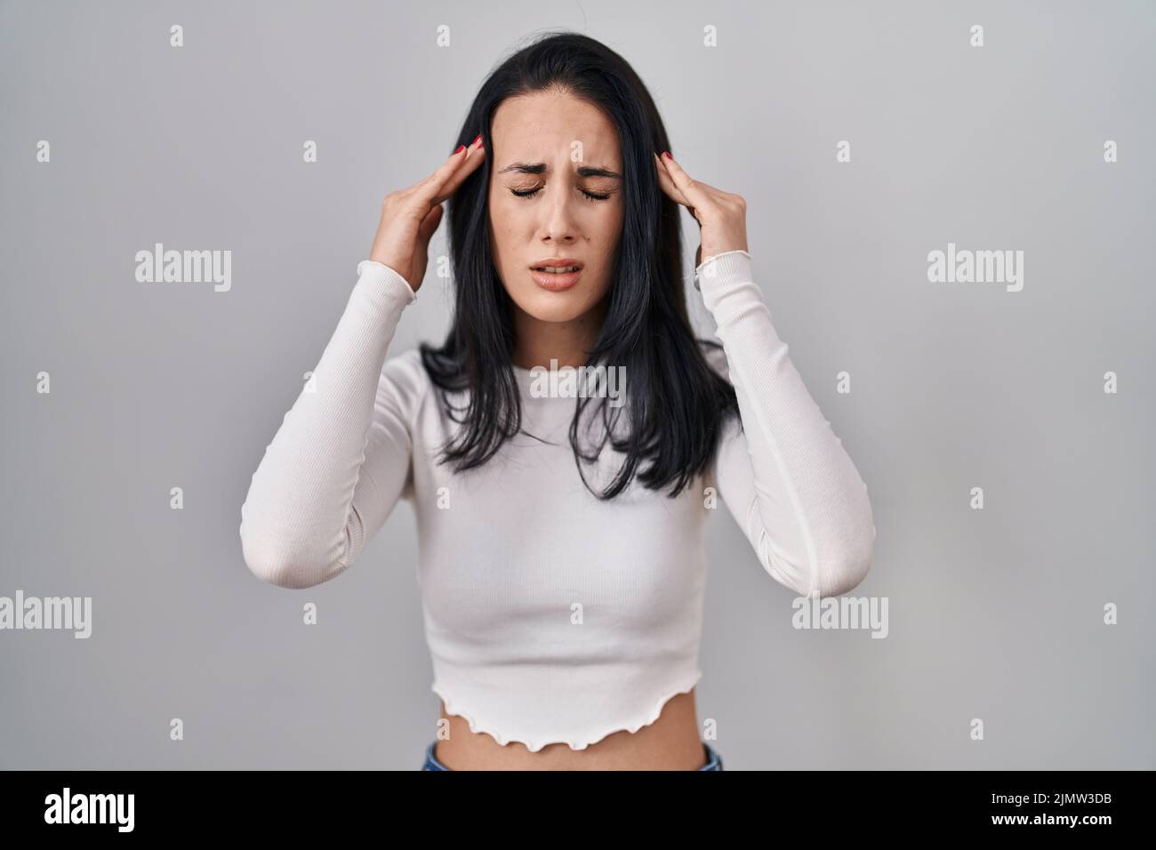 Hispanic woman standing over isolated background with hand on head for ...