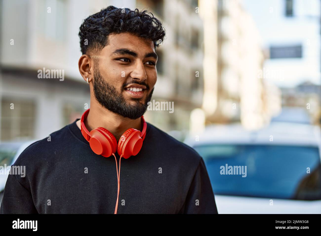 Young arab man smiling confident wearing headphones at street Stock ...