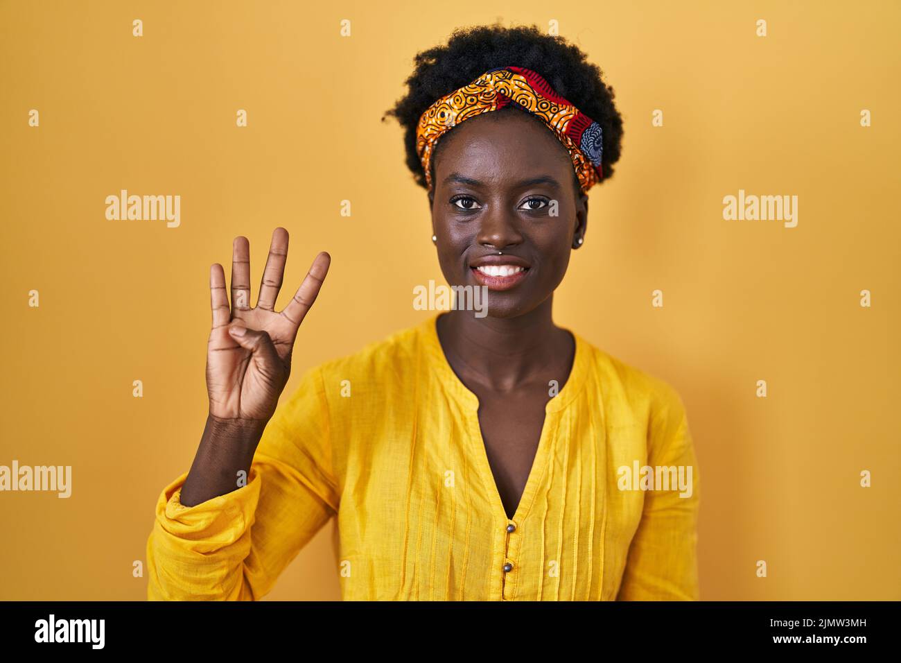 African young woman wearing african turban showing and pointing up with ...
