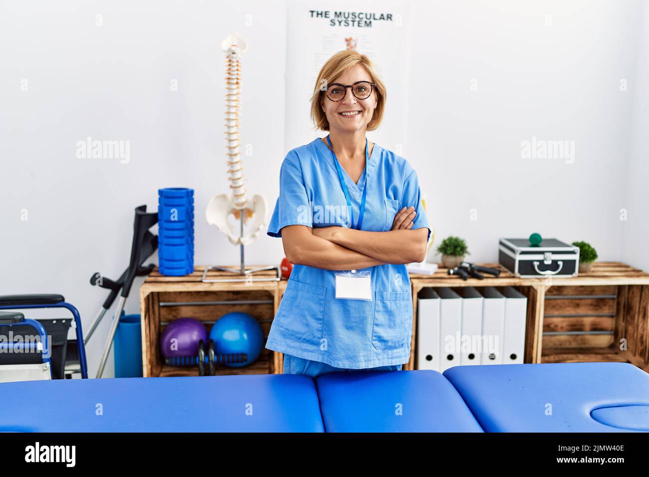 Middle age blonde woman wearing physio therapy uniform standing with ...