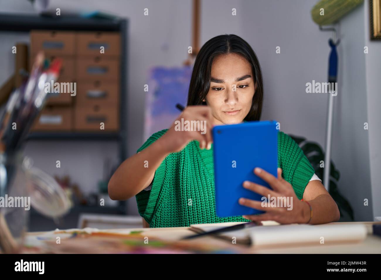 Young hispanic woman artist drawing on touchpad at art studio Stock ...