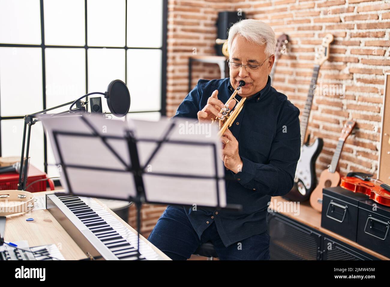 Senior man musician playing trumpet at music studio Stock Photo - Alamy