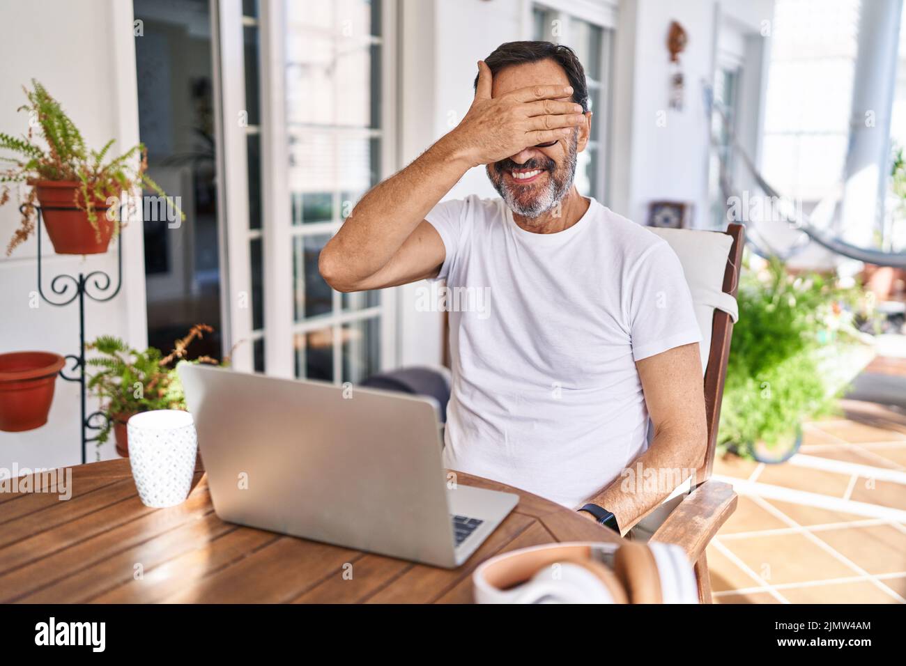 Middle age man using computer laptop at home smiling and laughing with ...