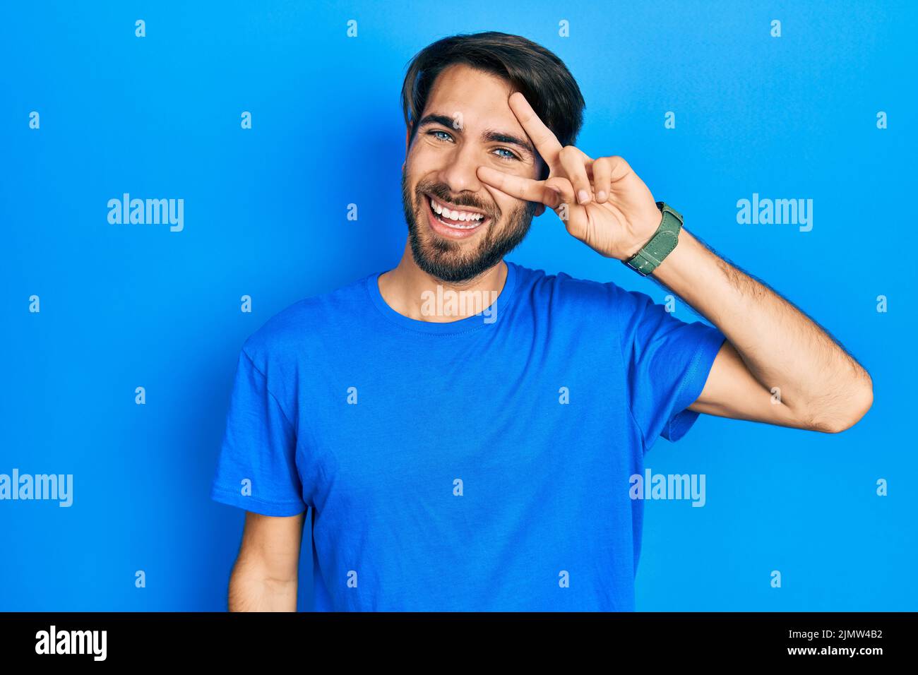 Young hispanic man wearing casual clothes doing peace symbol with ...