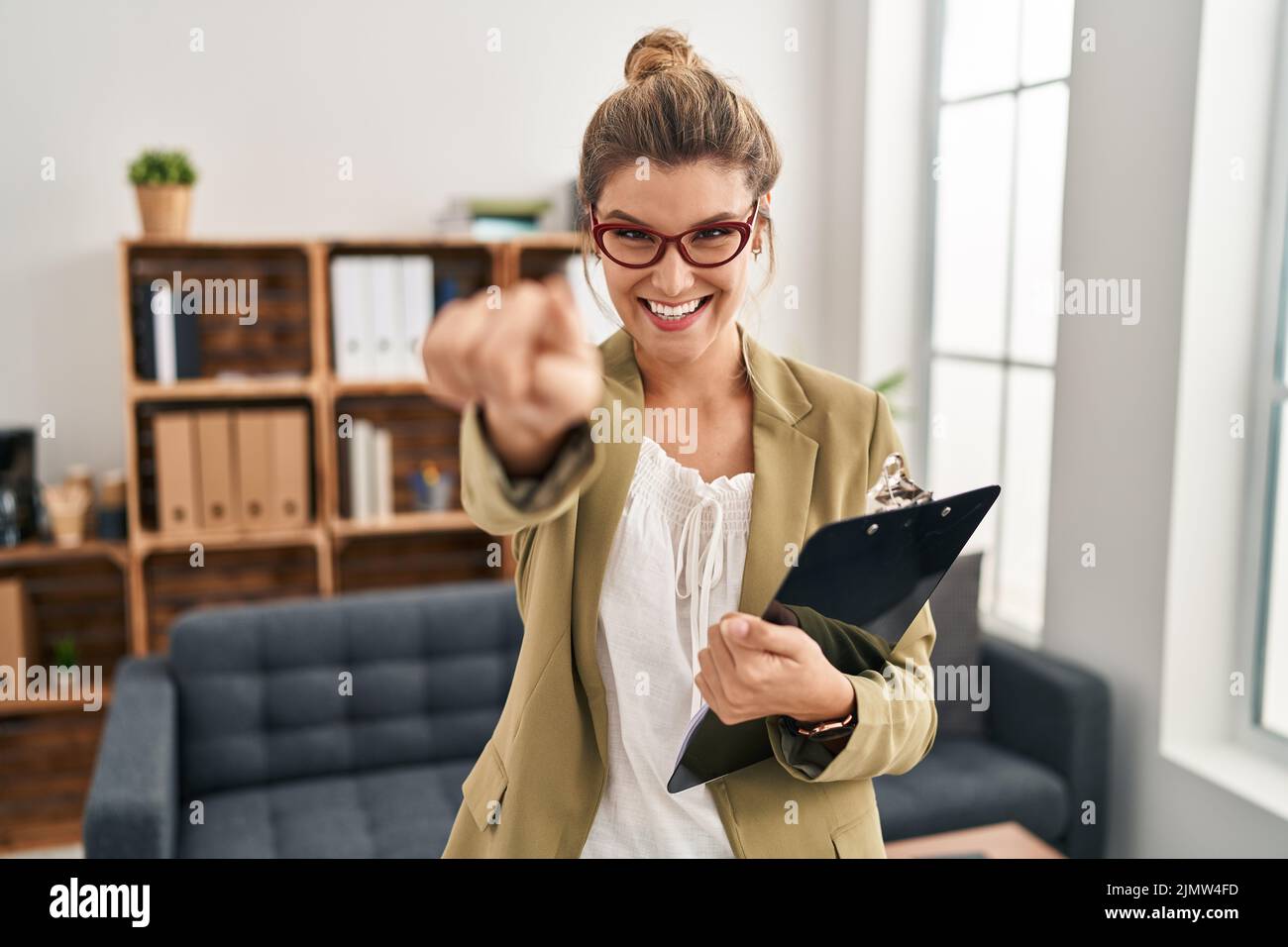Young woman working at consultation office pointing to you and the ...