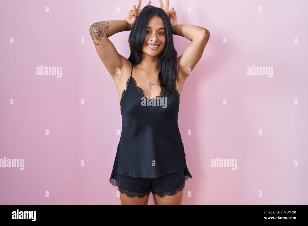 Brunette Woman Wearing Black Pajama Posing Funny And Crazy With Fingers
