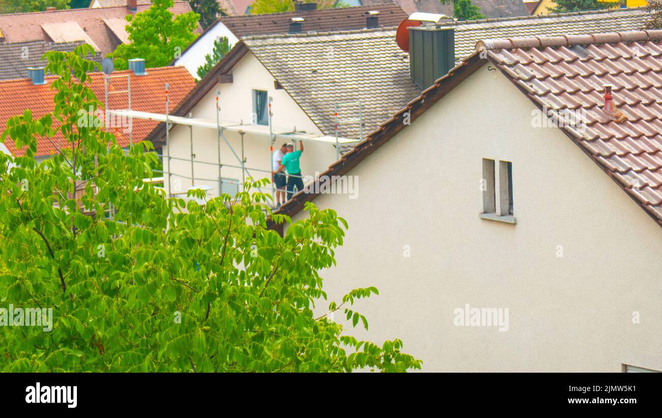 Construction and repair of the house. Builders on scaffolding on city ...