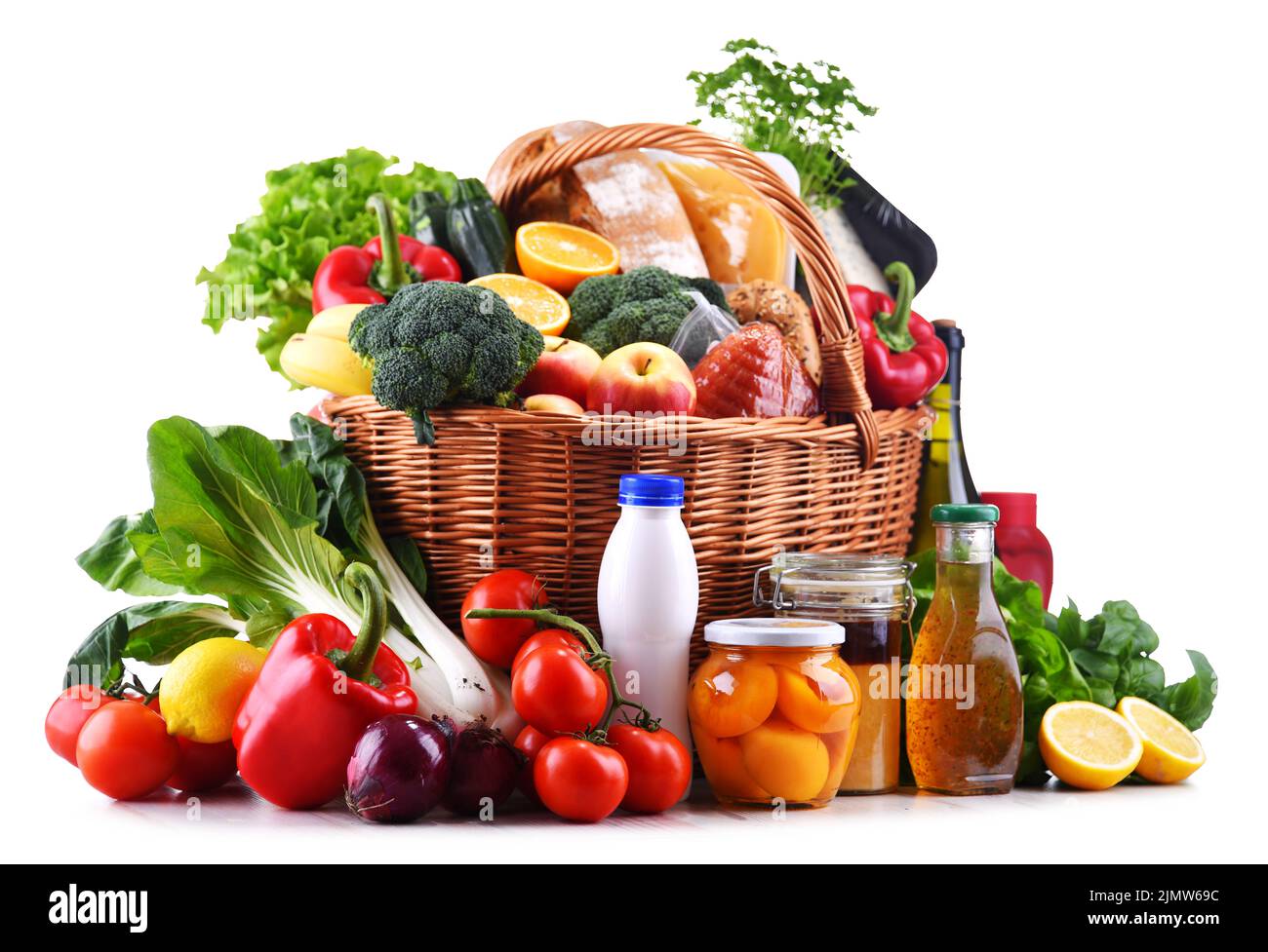 Wicker basket with assorted grocery products including fresh vegetables ...