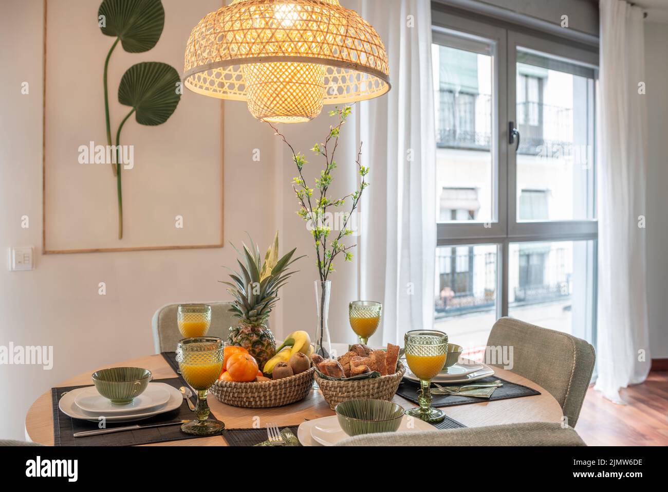 Round wooden dining table with breakfast service with sweets, orange ...