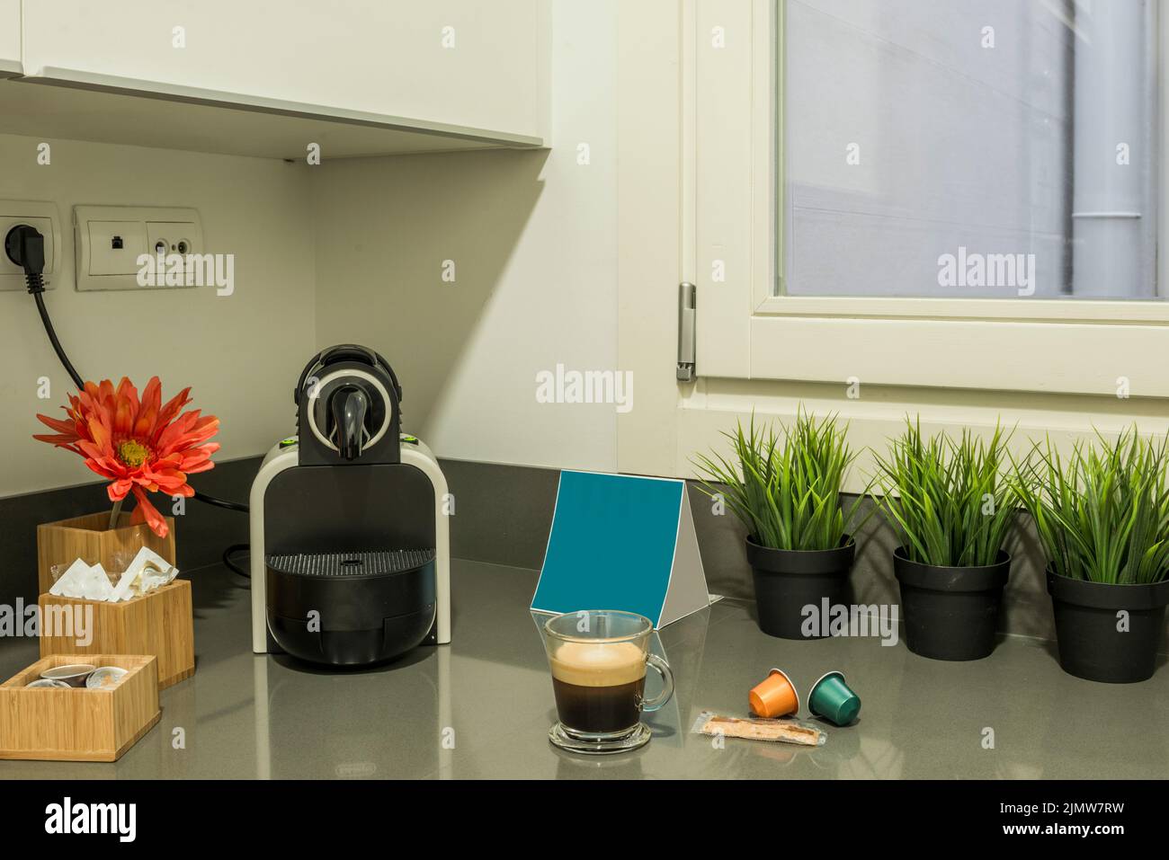 Capsule coffee machine, freshly brewed coffee and gray stone ...
