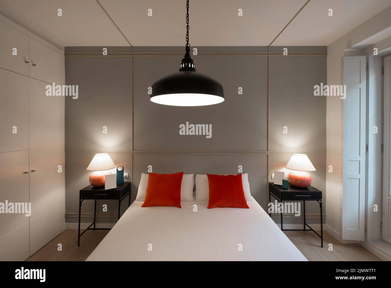 Bedroom with modern spartan-style furniture, built-in wardrobe and red ...