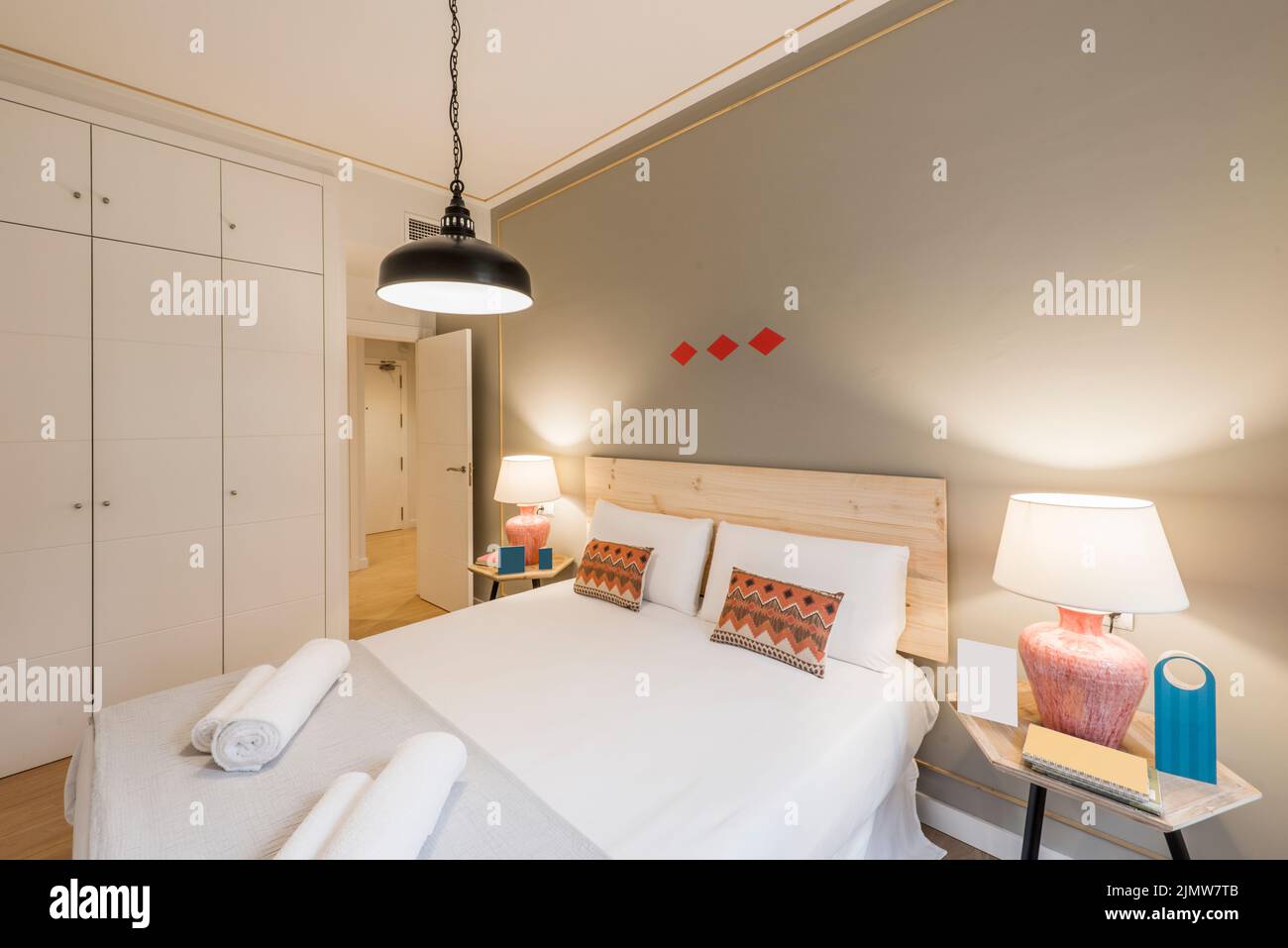 Bedroom with a double bed with an ecru wooden headboard, matching side ...