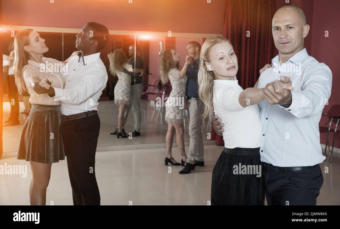 Positive people learning to dance waltz together in dancing class Stock ...