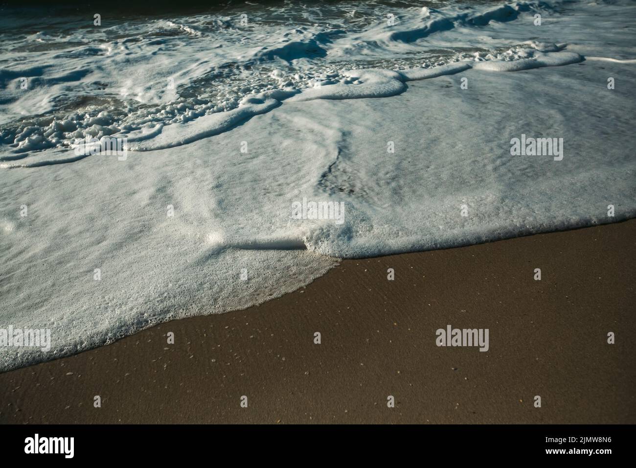 Foamy surf during sunset on the ocean coast Stock Photo - Alamy