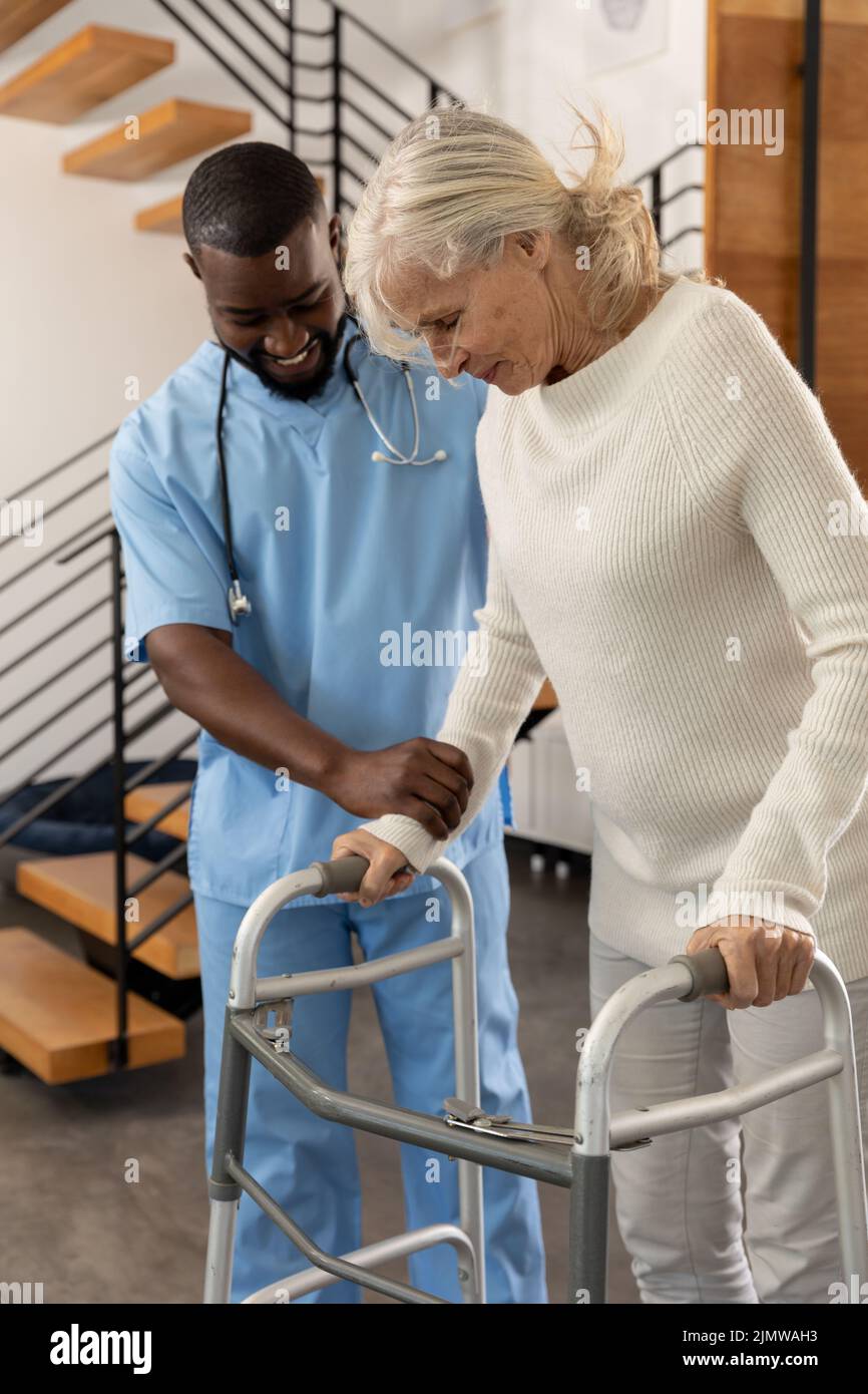 African american male health worker helping caucasian senior woman to ...